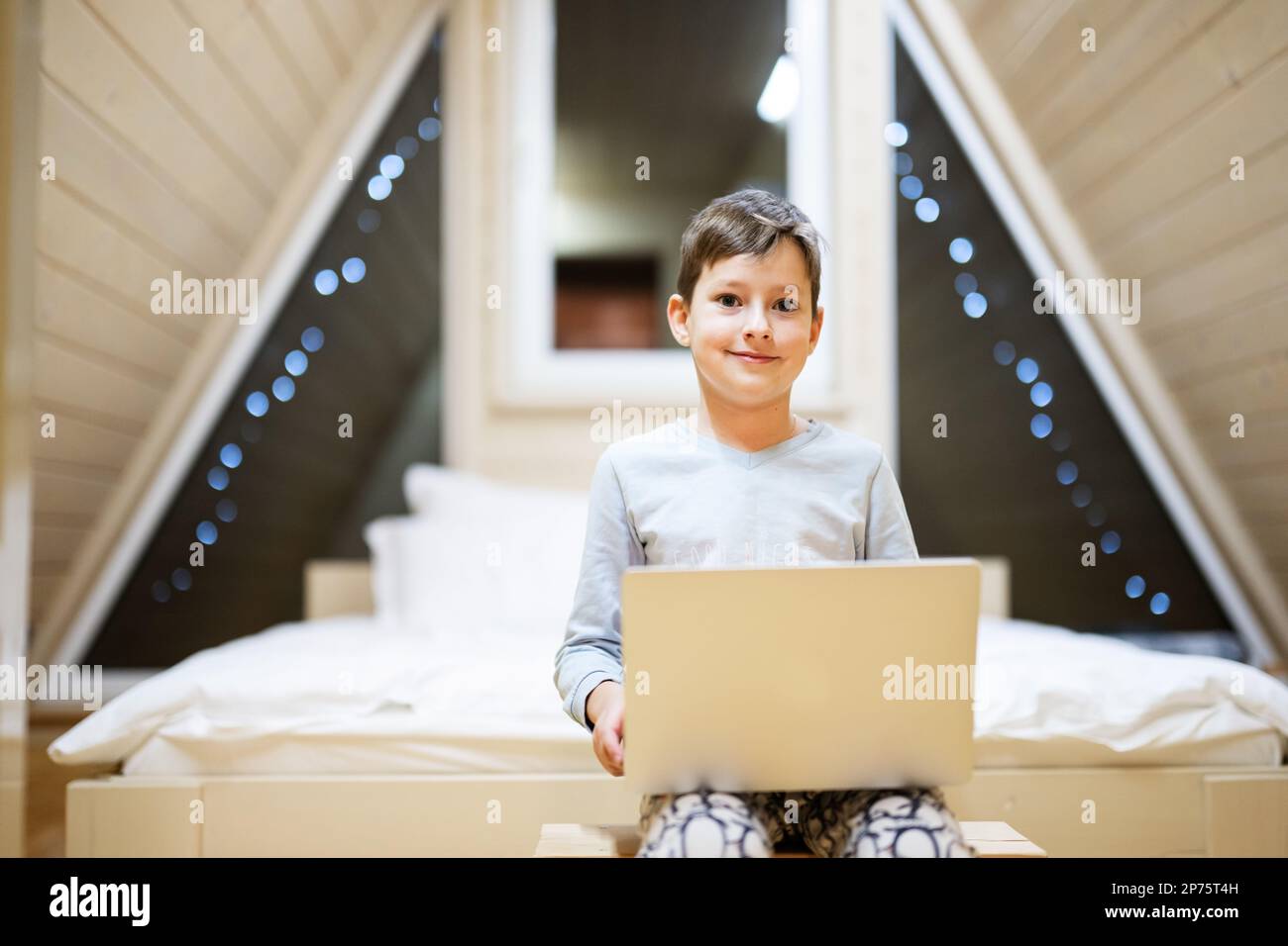 Boy in pajama sit with laptop at wooden cabin home. Concept of ...