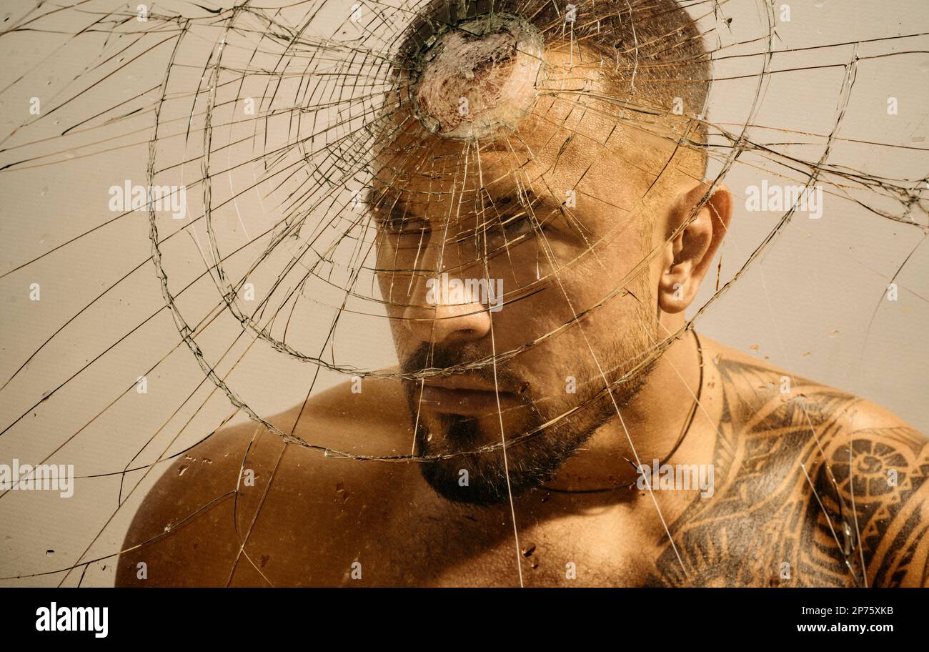 Overcoming the obstacle. Determined man knocking down a glass wall with ...