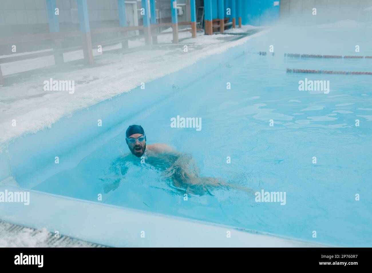 Fit swimmer male training swim breaststroke in open winter swimming ...