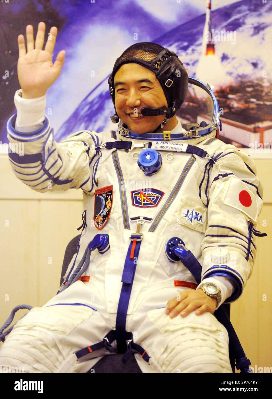 Japanese astronaut Satoshi Furukawa waves his hand before abording ...