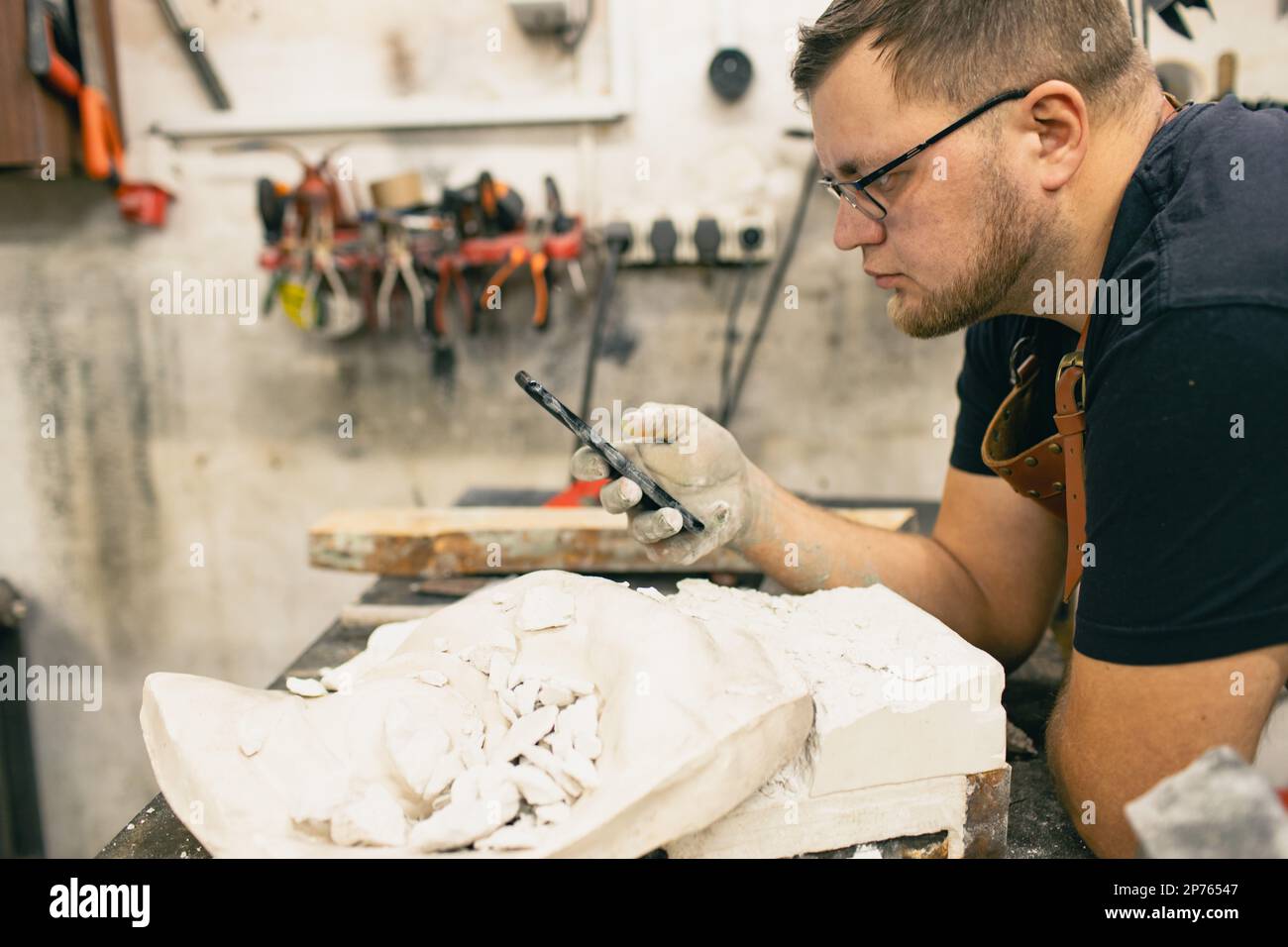 Man sculptor creates sculpt bust clay human woman sculpture and calling ...