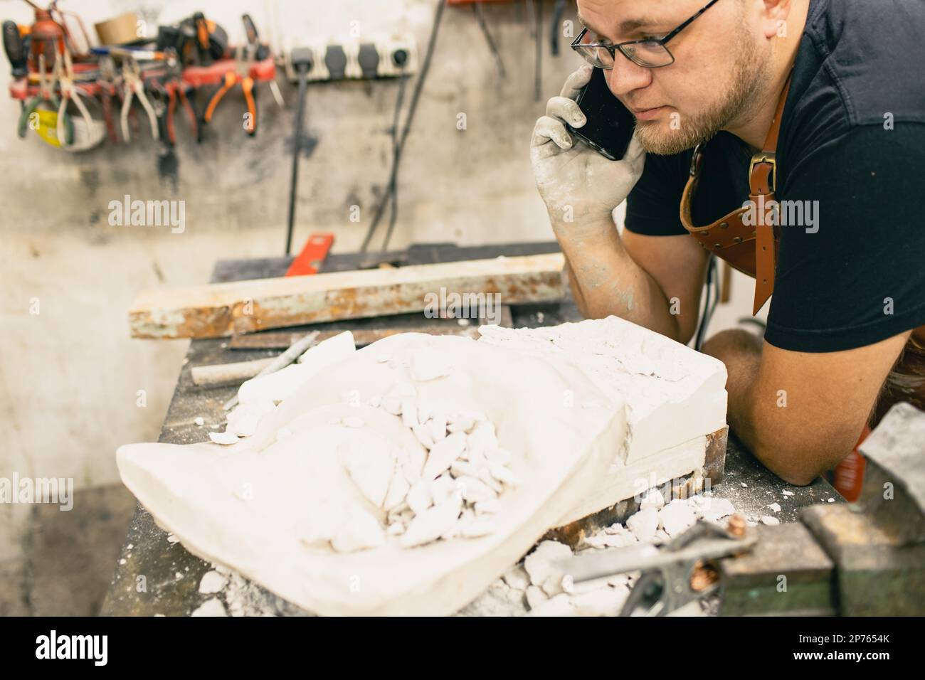 Man sculptor creates sculpt bust clay human woman sculpture and calling ...