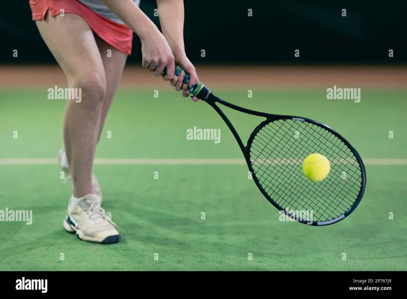 Tennis woman player legs playing training with racket and ball at court ...