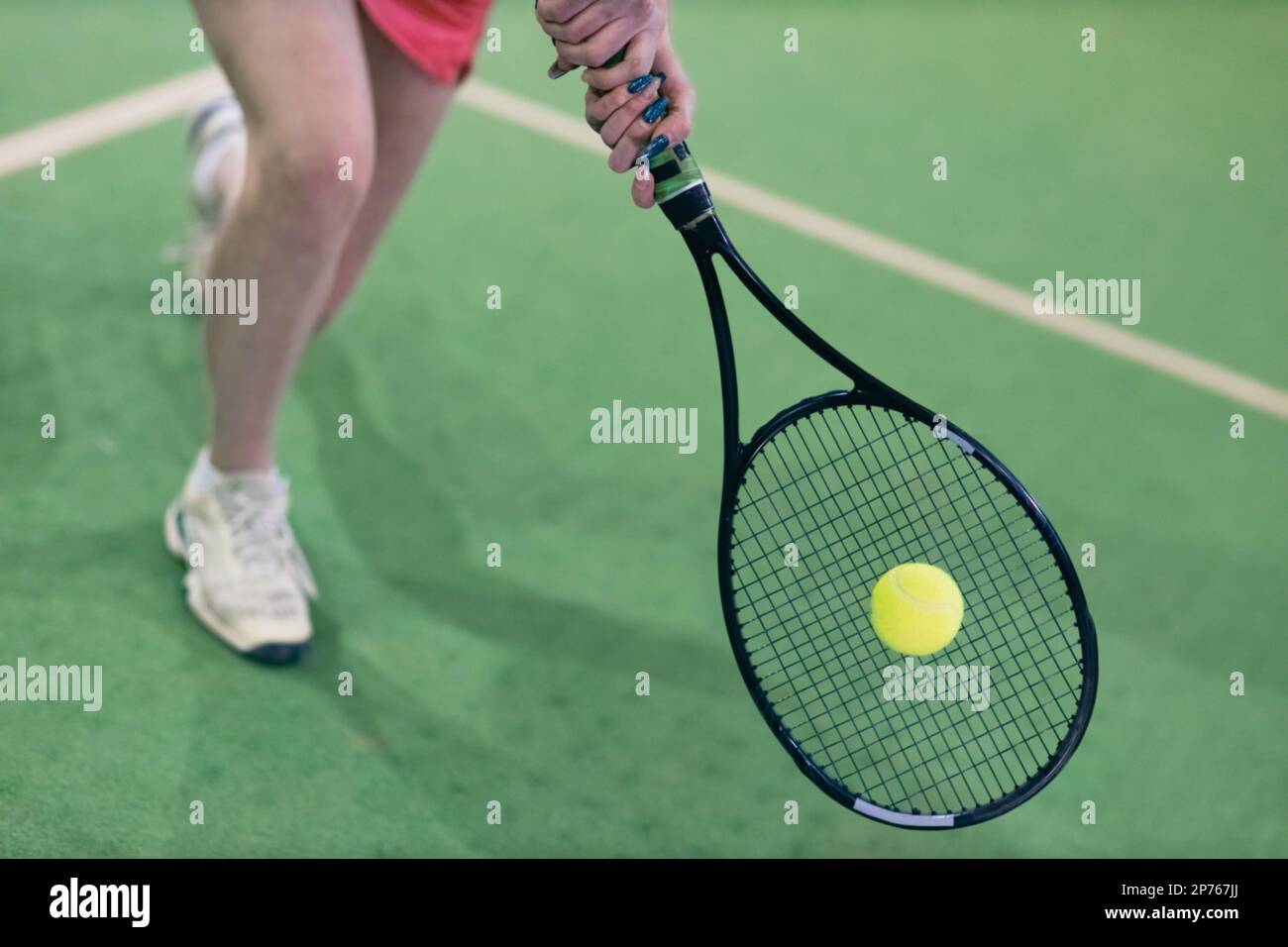 Tennis woman player legs playing training with racket and ball at court ...