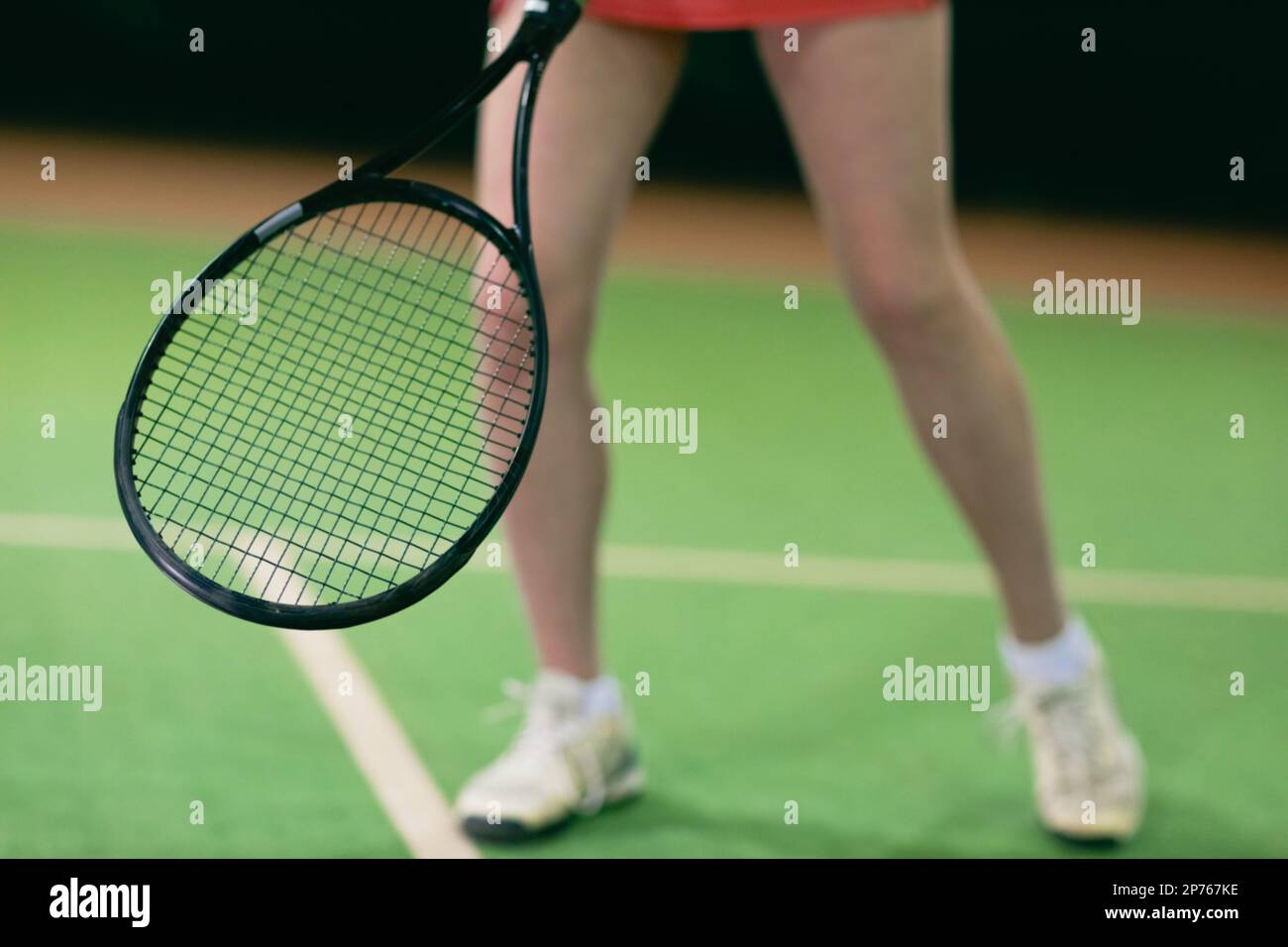 Tennis woman player legs playing training with racket and ball at court ...