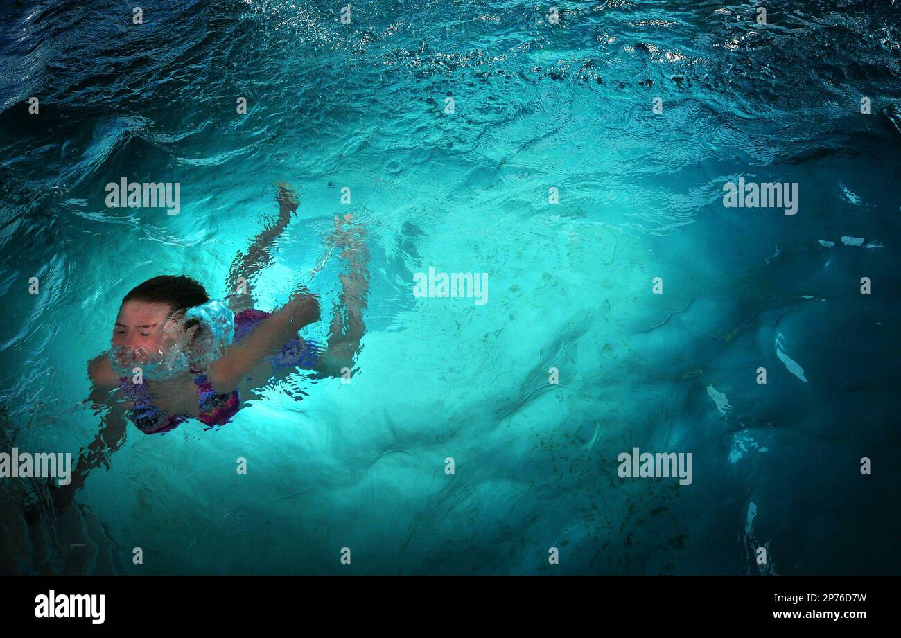 A swimmer surfaces after plunginginto the Tsunami Swirl pool at Kenwood ...