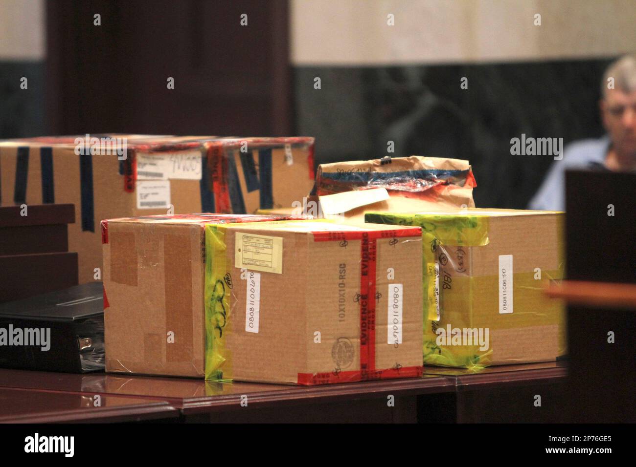 Evidence in sealed boxes sits in the courtroom on the opening day of ...
