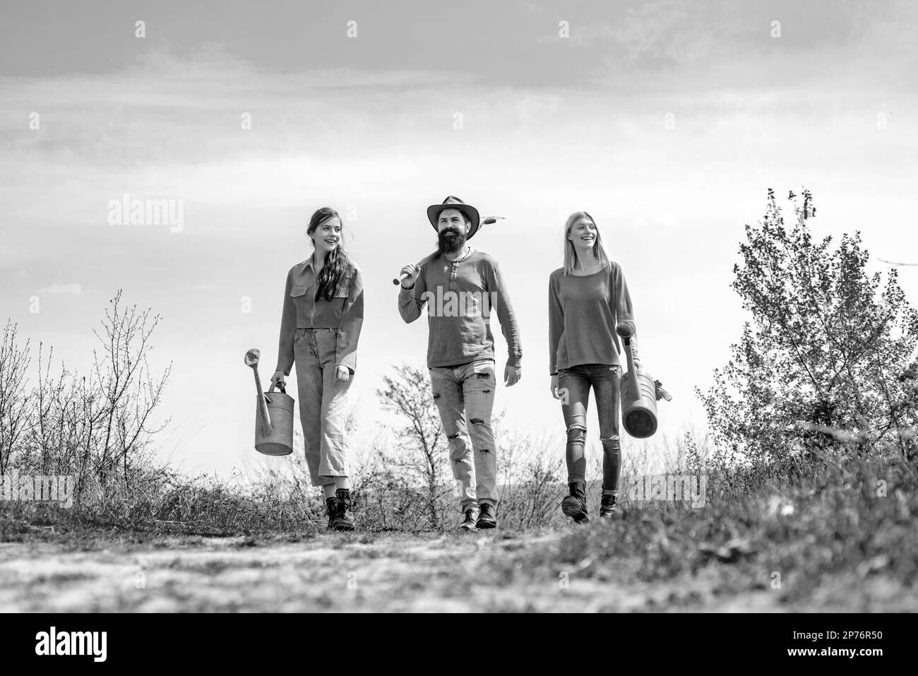 Funny friends walking in spring garden. Friends working in garden ...