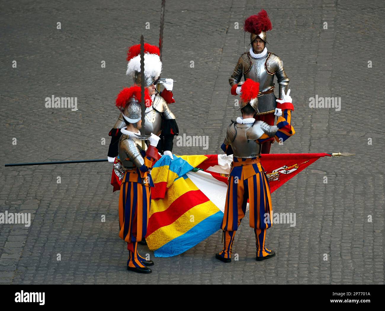 A new Vatican's Swiss Guard, bottom right, holds up three fingers ...