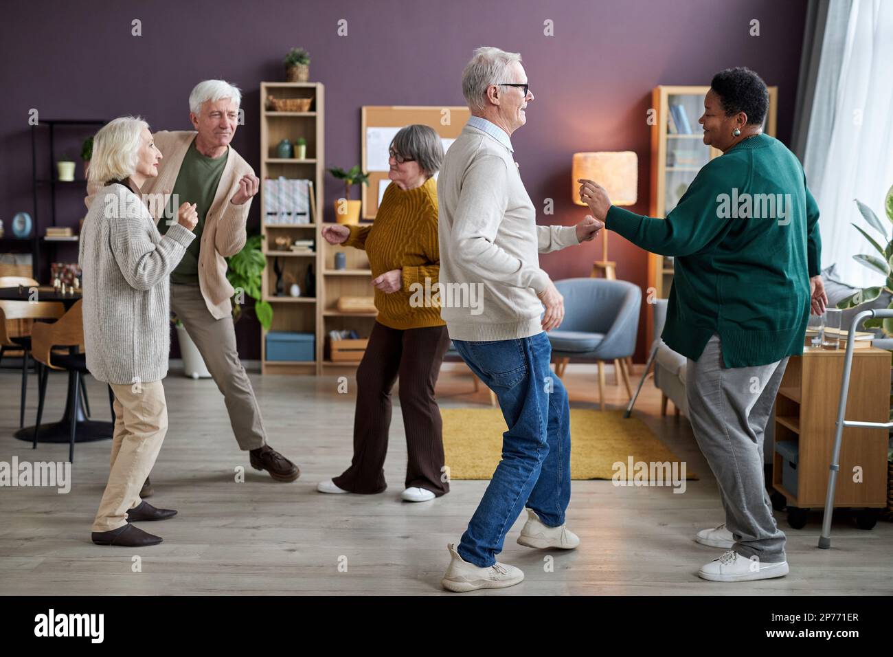 Full length view at group of senior people dancing in retirement home ...