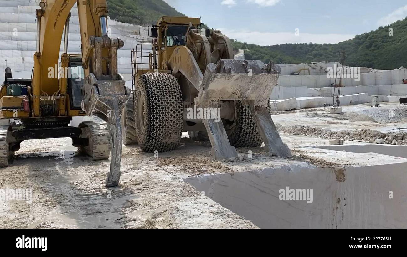 Wheel loader and excavator working at a huge marble quarry in Europe ...