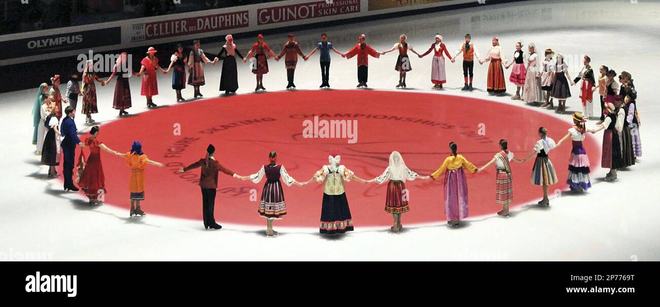 Skaters in local traditional costume, gather around a red circle on the ...