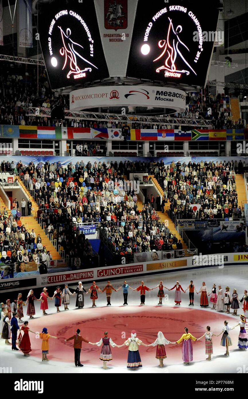 Skaters in local traditional costume, gather around a red circle on the ...