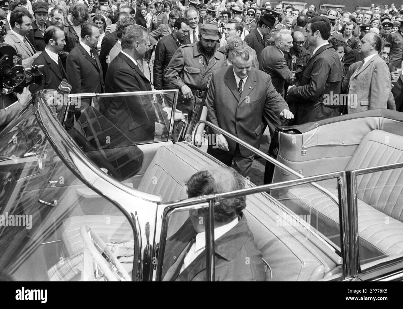 Cuban leader Fidel Castro, wearing a cap, follows an unidentified man ...
