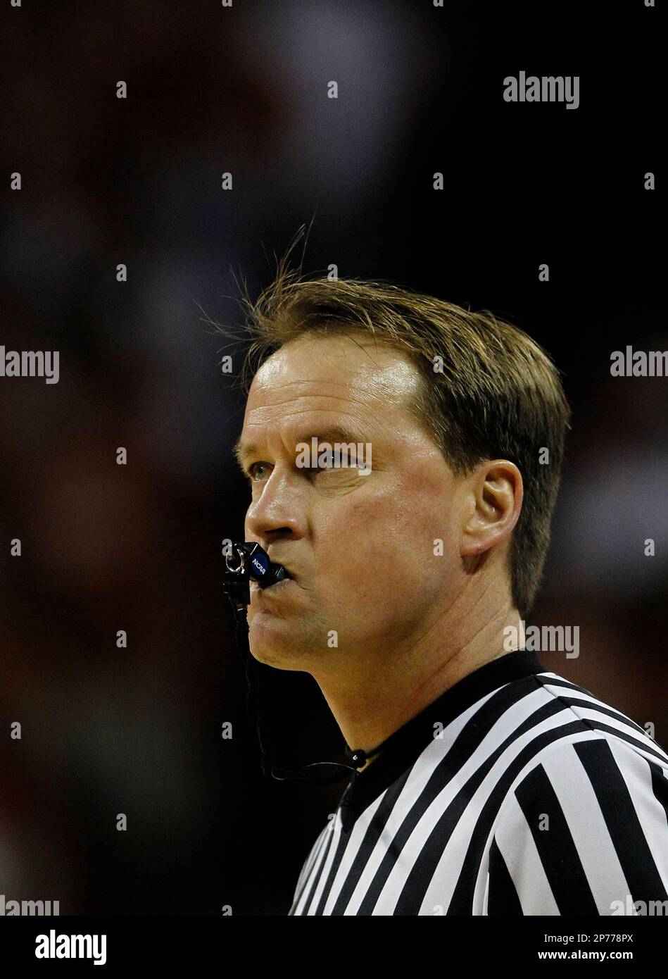 A detail view of an NCAA official blowing his whistle as he works an ...