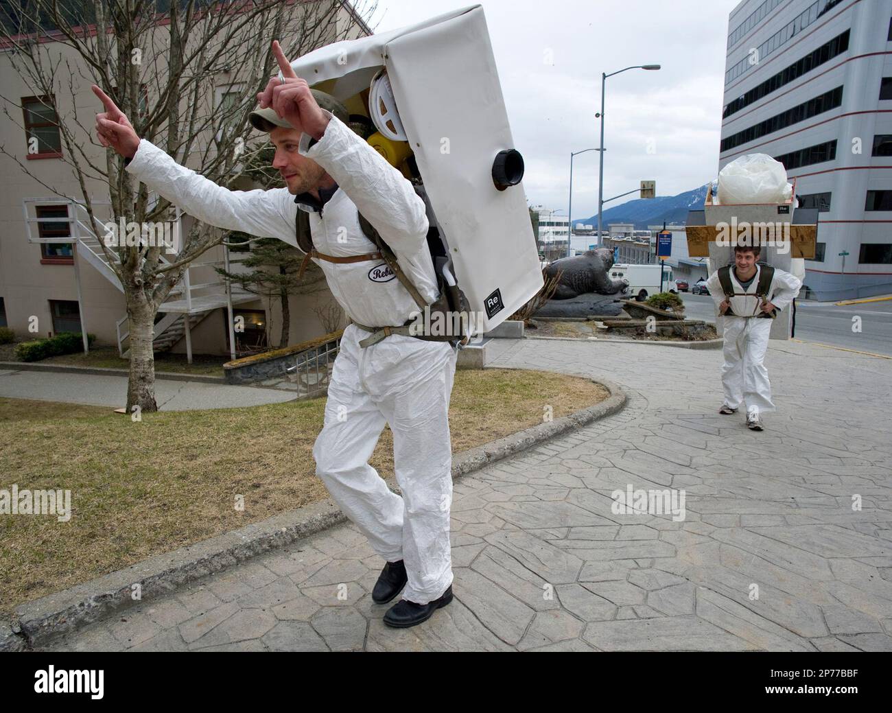 Blaine Merker, left, and Adam Green of REBAR carry the two backpacks to ...