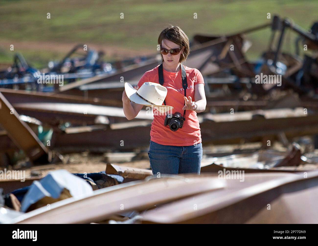 Alicia Brinley, pulls a untouched cowboy hat out of the tornado debris ...