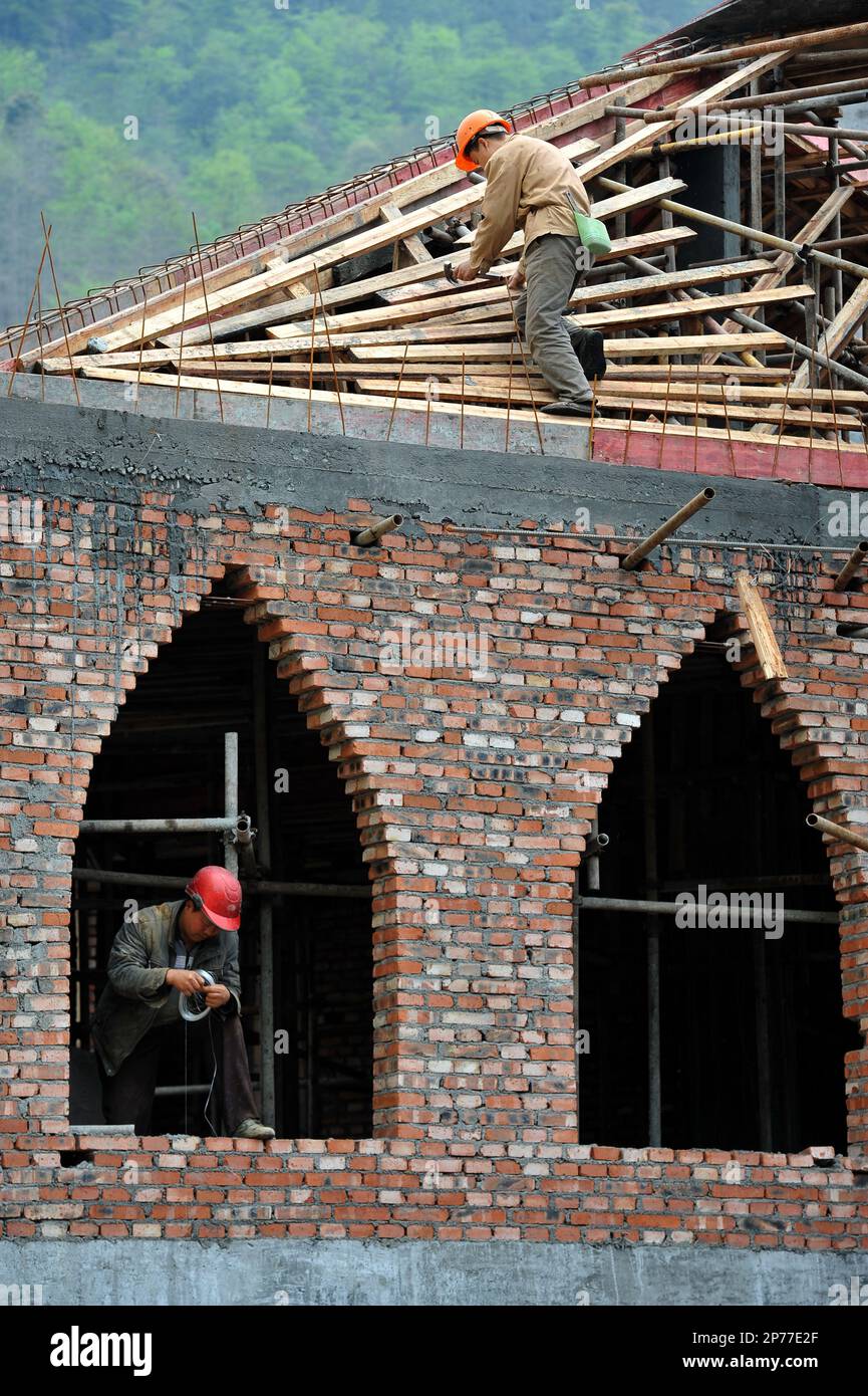 Workers build a Europe-style house at Bailu town in Pengzhou in Chengdu ...