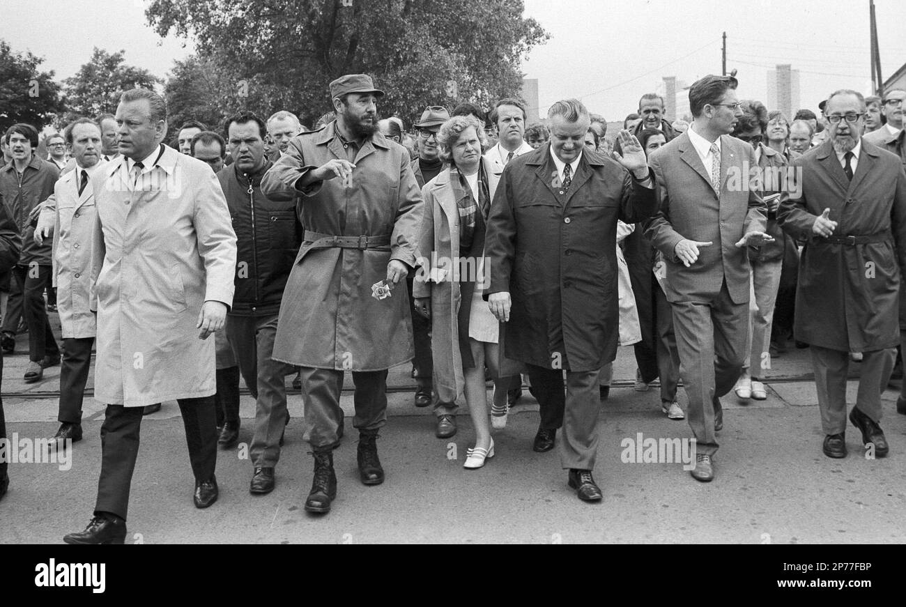 Cuban leader Fidel Castro, wearing a cap, is accompanied by a group of ...