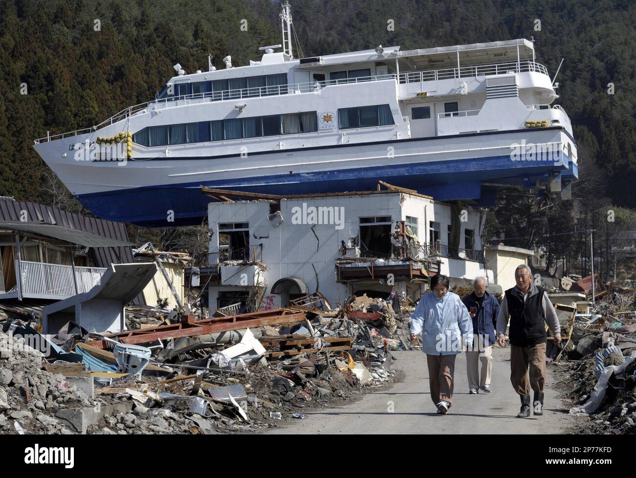 People walk through the rubble in Otsuchi, northern Japan Sunday, April ...