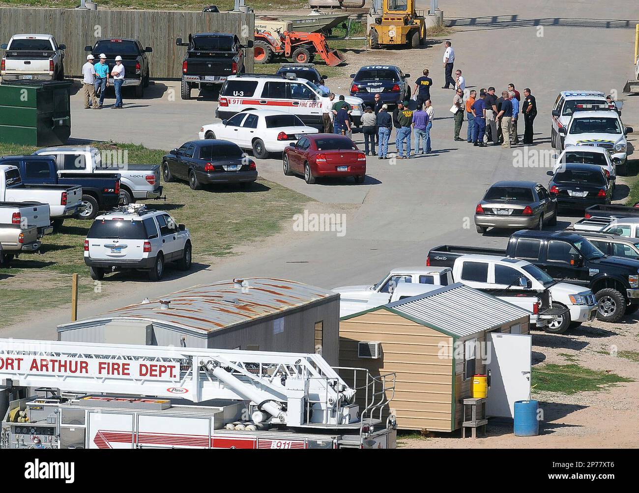 Emergency officials gather in the parking lot of KMTEX chemical ...