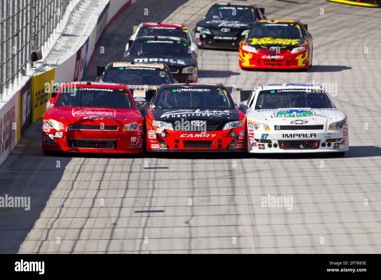 BRISTOL, TN - MAR 19, 2011: Kyle Busch (18), Willie Allen (05) and Joe Nemechek (87) make it ...