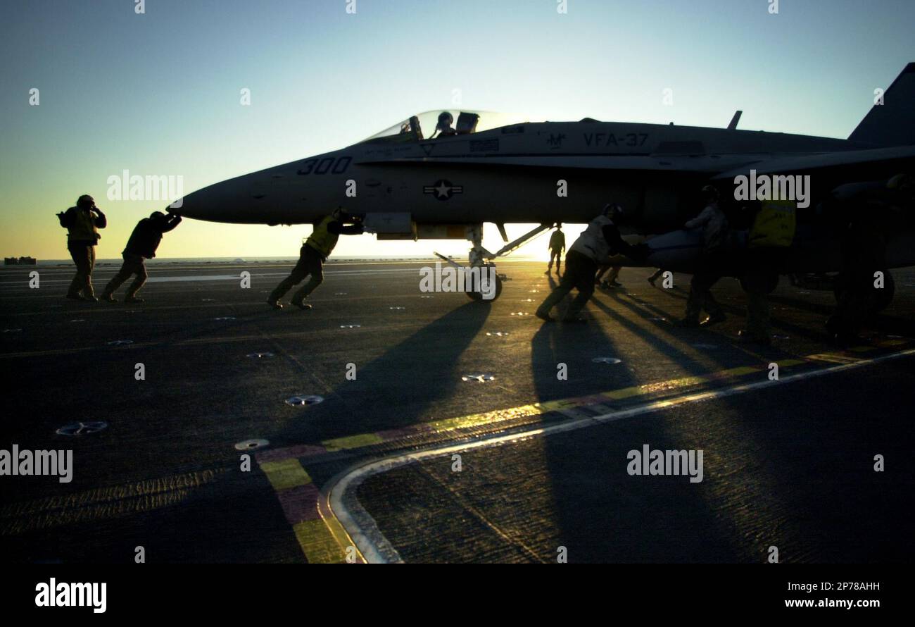 An F-18 Hornet is maneuvered into position for launching off the deck ...