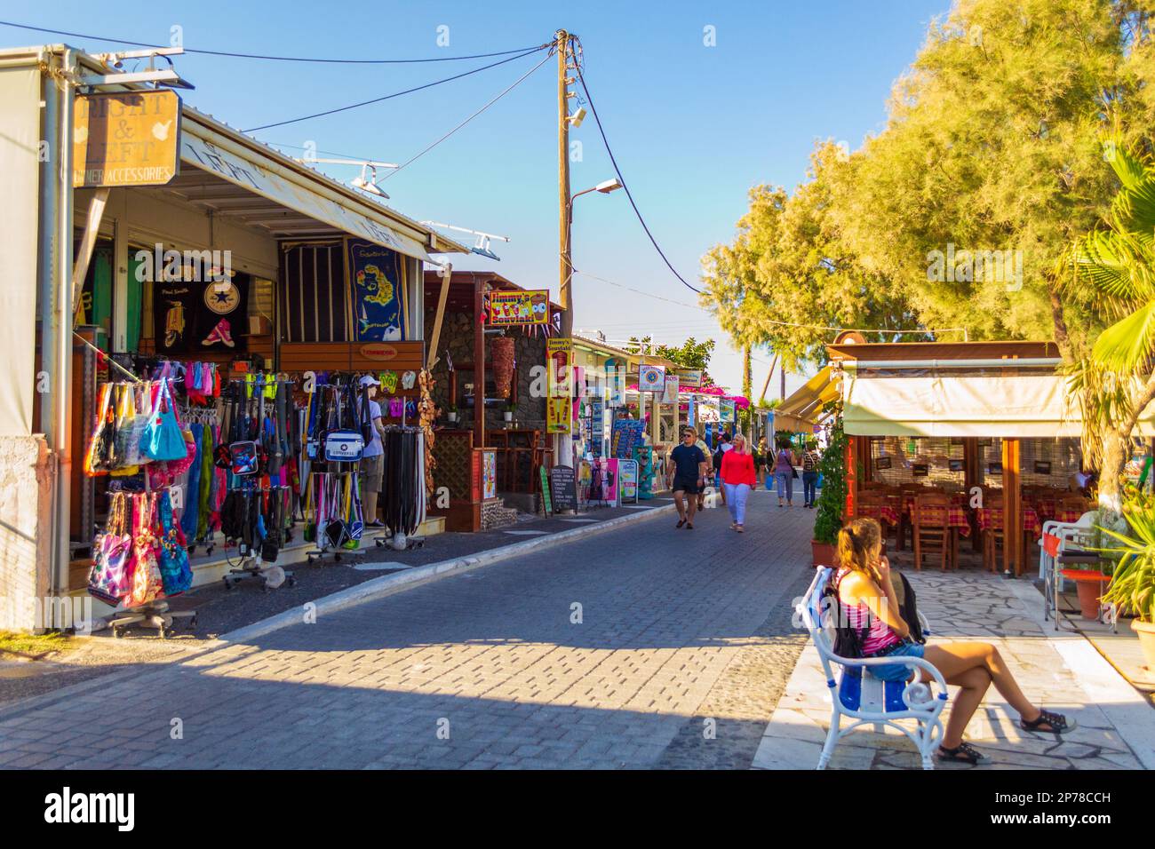 Stores and restaurants along beach side promenade in Kamari resort ...