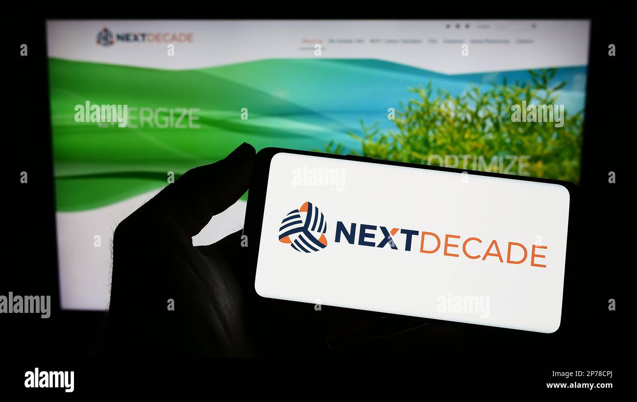 Person holding smartphone with logo of US energy company NextDecade ...