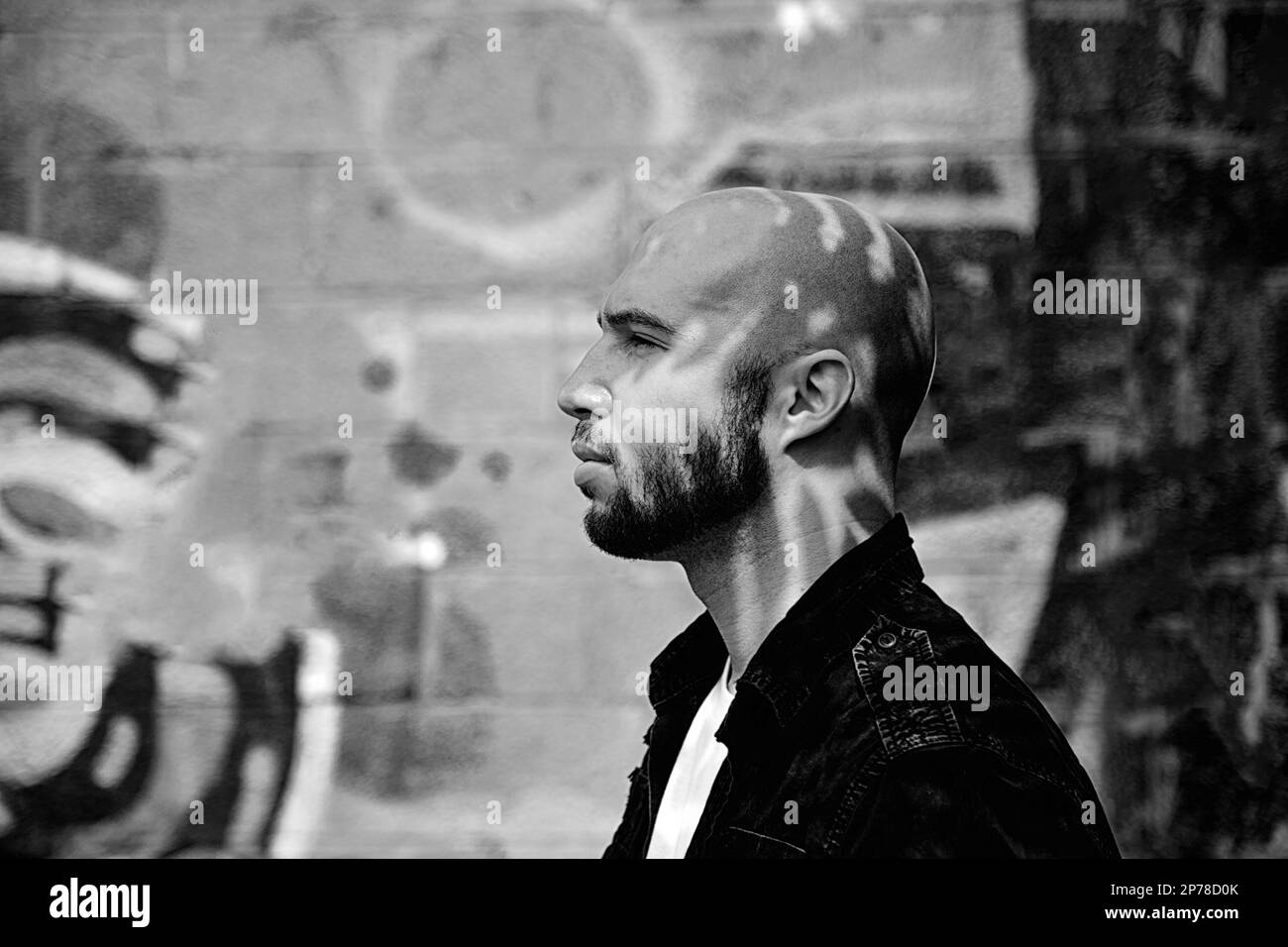 Young dangerous gang member looking at something on the city street ...