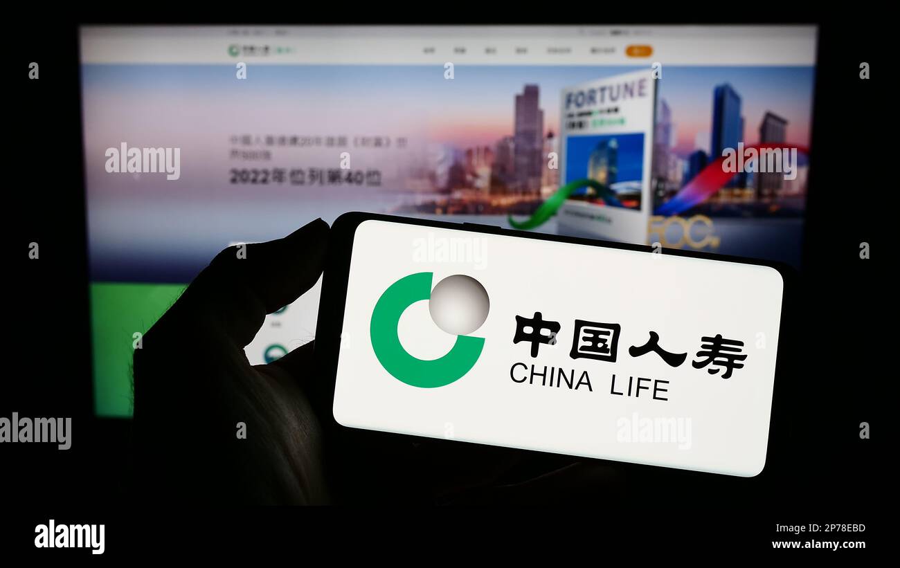 Person holding mobile phone with logo of company China Life Insurance ...