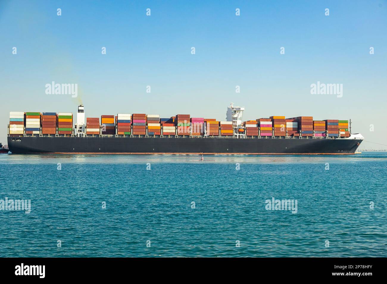 Large cargo container ship loaded with containers against the blue sky ...