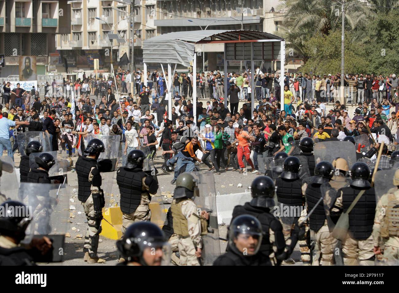 Iraqi riot police officers prevent anti-government protesters from ...