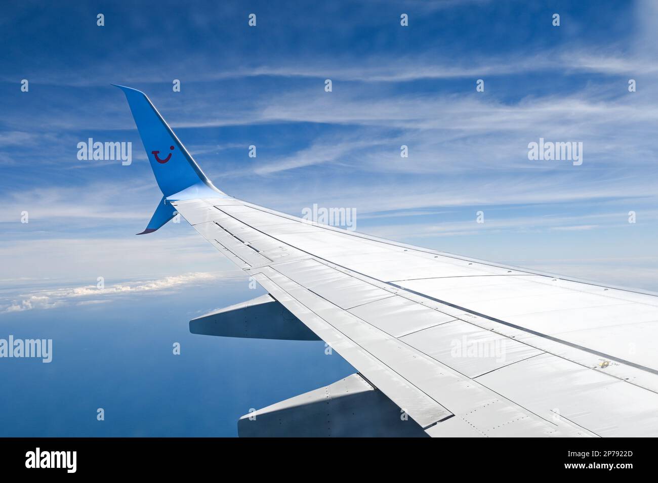 A wing of a Boeing 737 TUI chartered airplane taken in flight showing ...