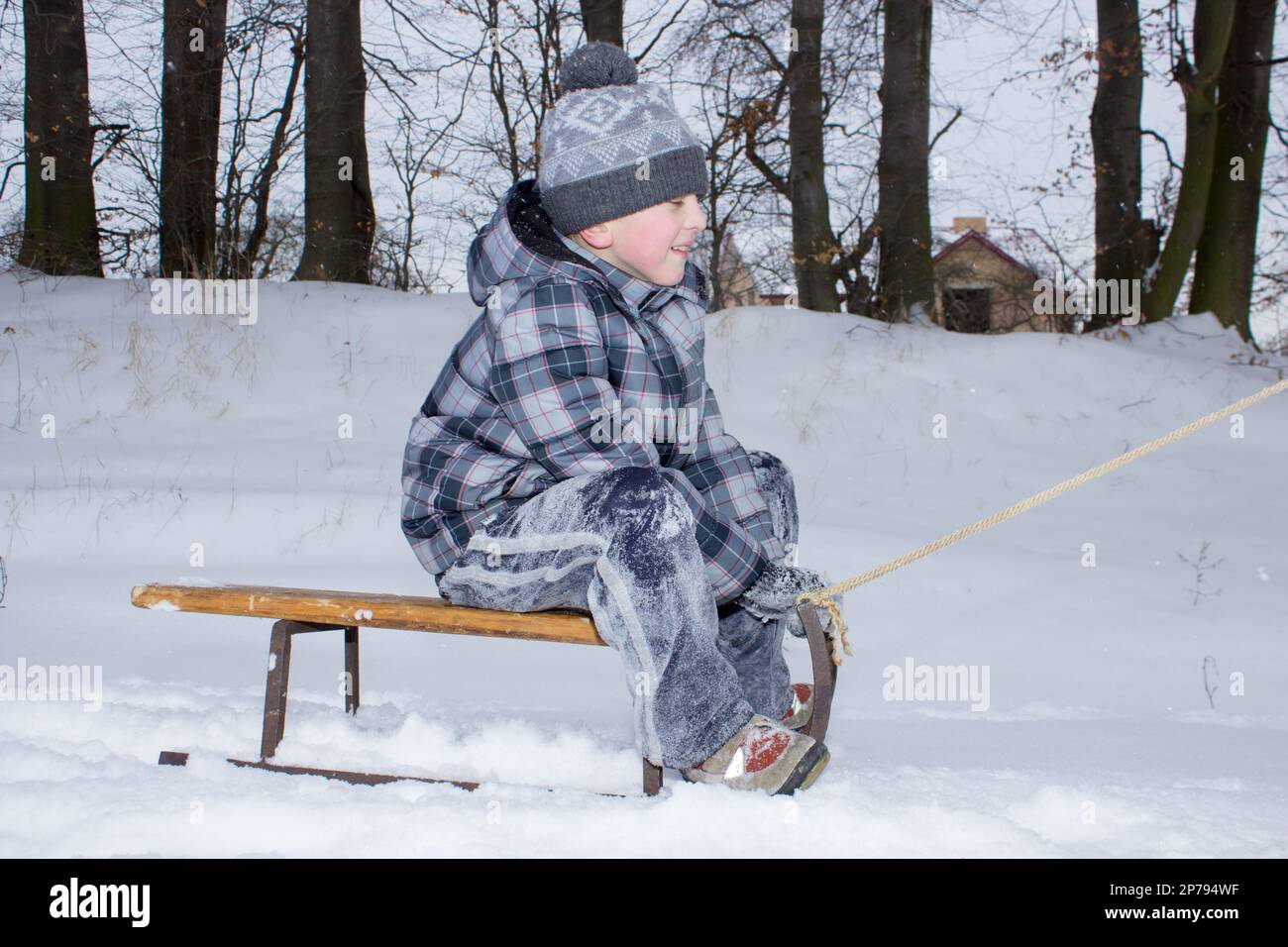 Winter fun - sledding at winter time. Young boy enjoying a sledge ride ...