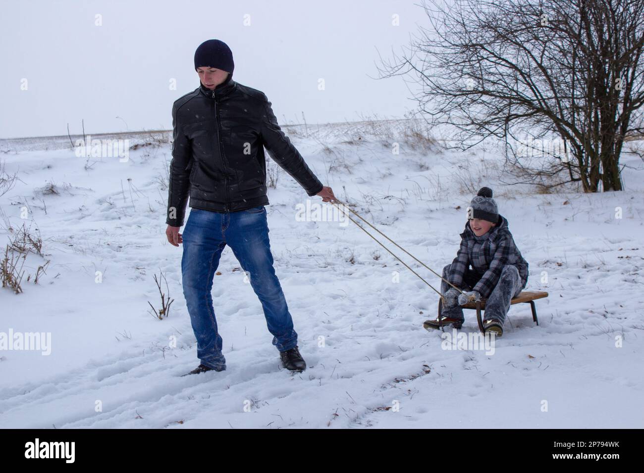 boy pulled by sled younger brother Stock Photo - Alamy