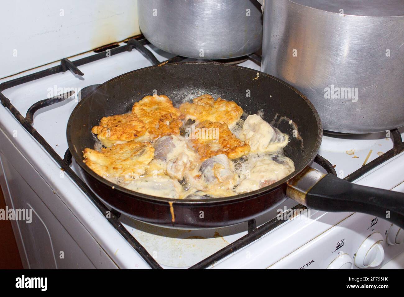 Cook fish fry in a frying pan in the kitchen Stock Photo - Alamy