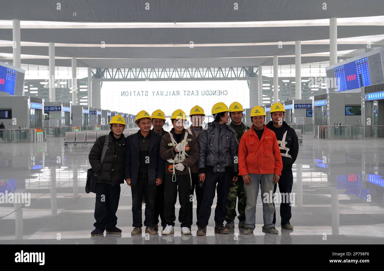 Workers pose for photos at the departure hall of the new Chengdu East ...
