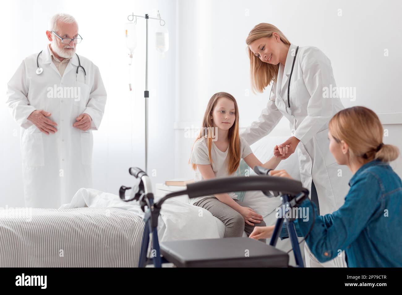 Doctor helping young girl after surgery to stand up Stock Photo - Alamy