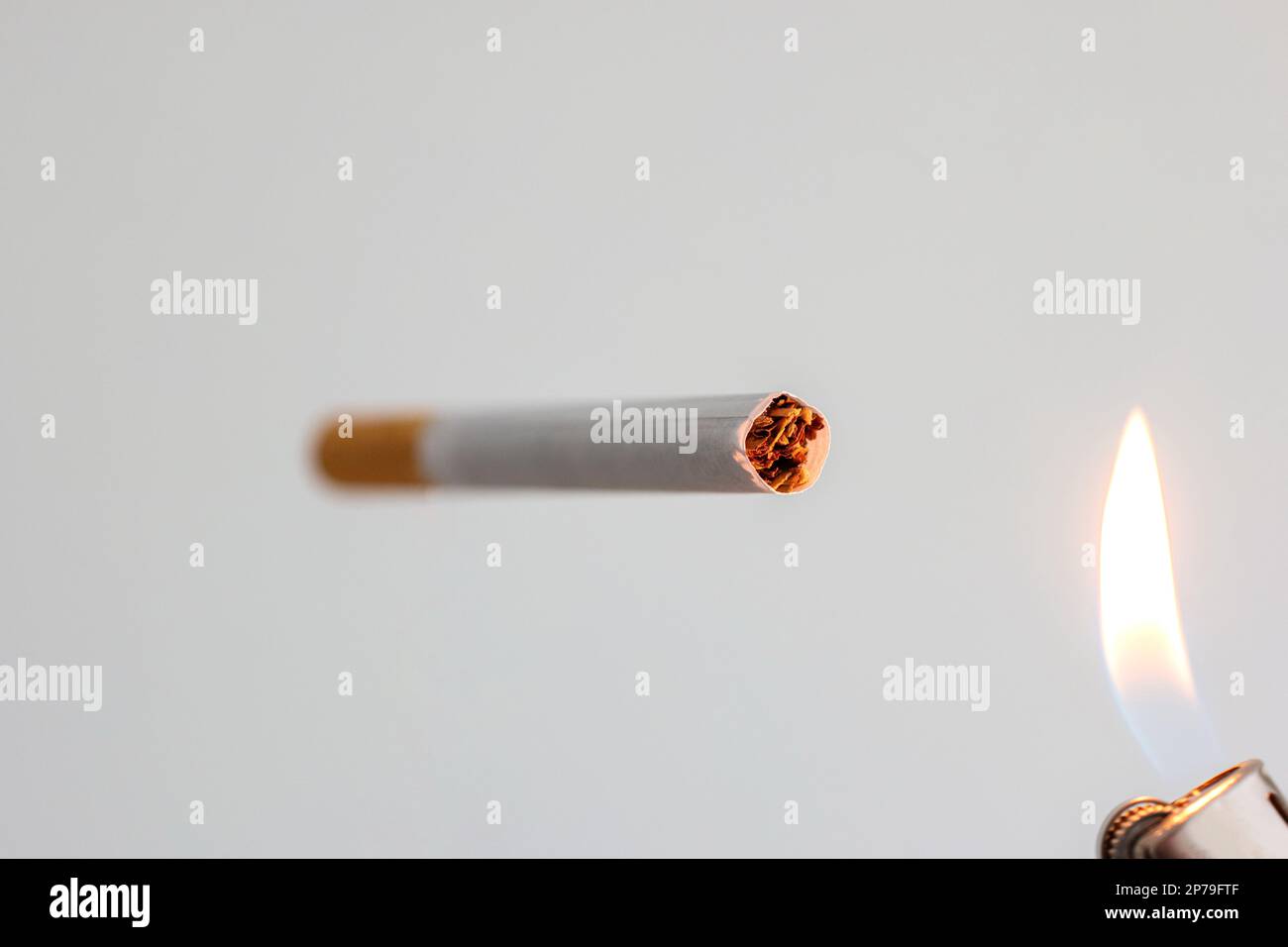 Single unlit cigarette stick close to open flame fire from lighter ... Single unlit cigarette stick close to open flame fire from lighter ...