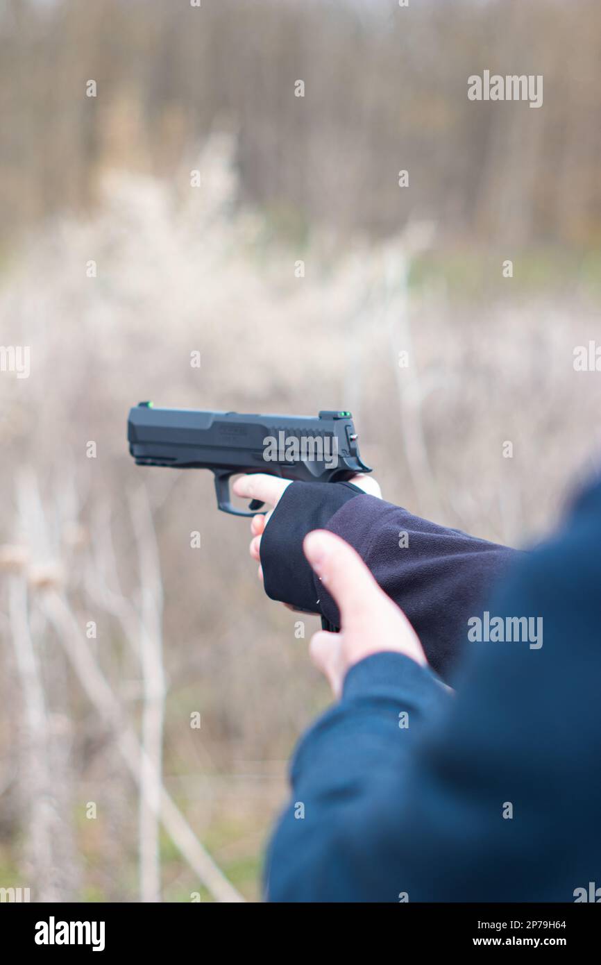 Young female arms and hands aiming a hand gun in self-defence training ...