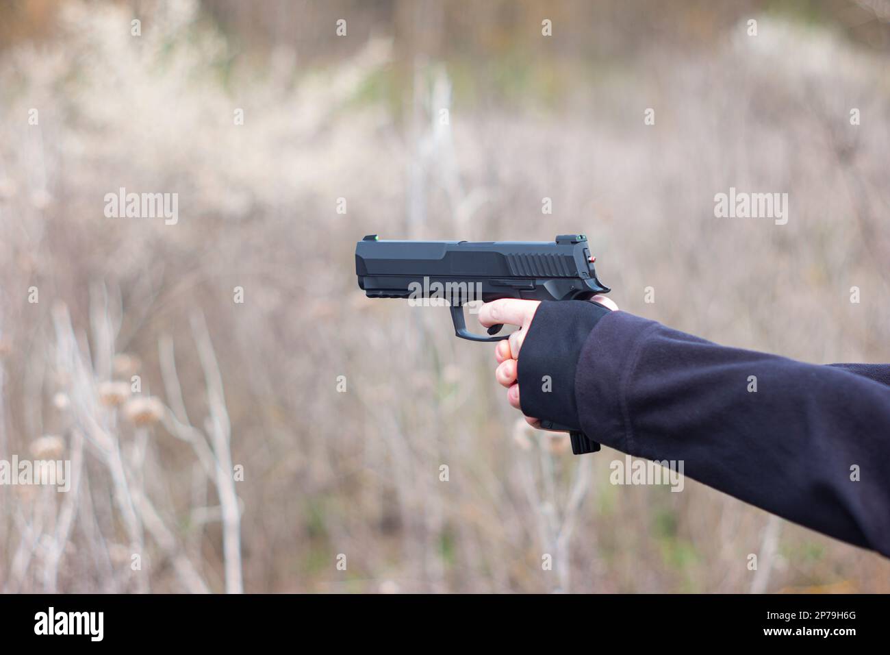 Young female arms and hands aiming a hand gun in self-defence training ...