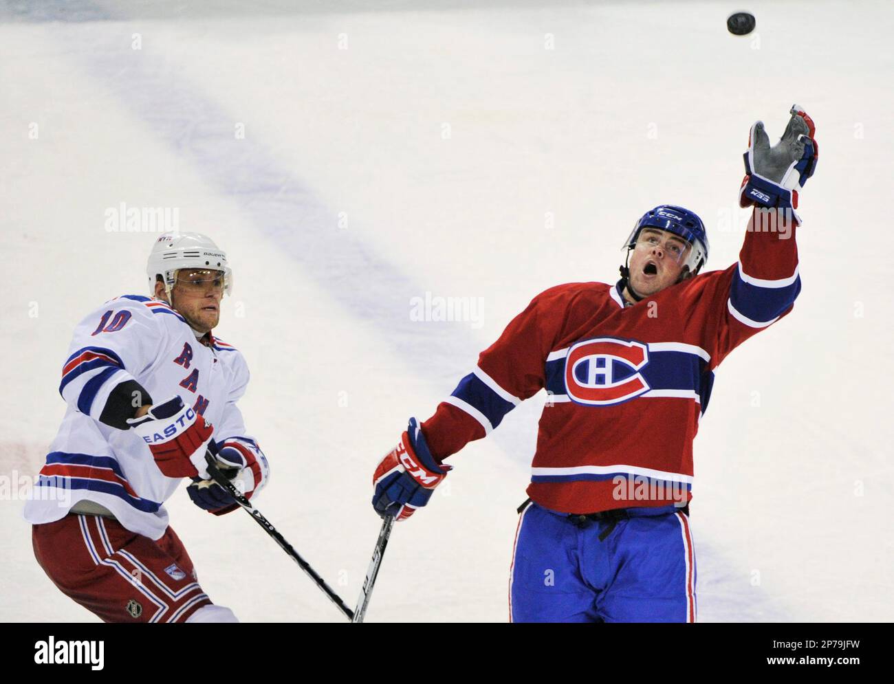Montreal Canadiens' Yaroslav Spacek, right, jumps up to catch the puck ...