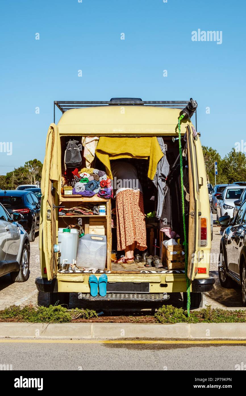 A yellow camper van with busy woman inside parked on a crowded parking ...