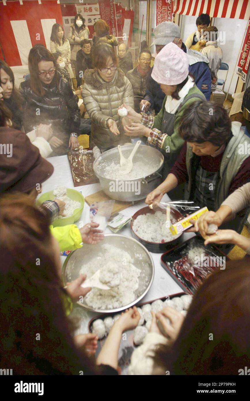 Local people prepare food such as rice balls for passengers of a train ...