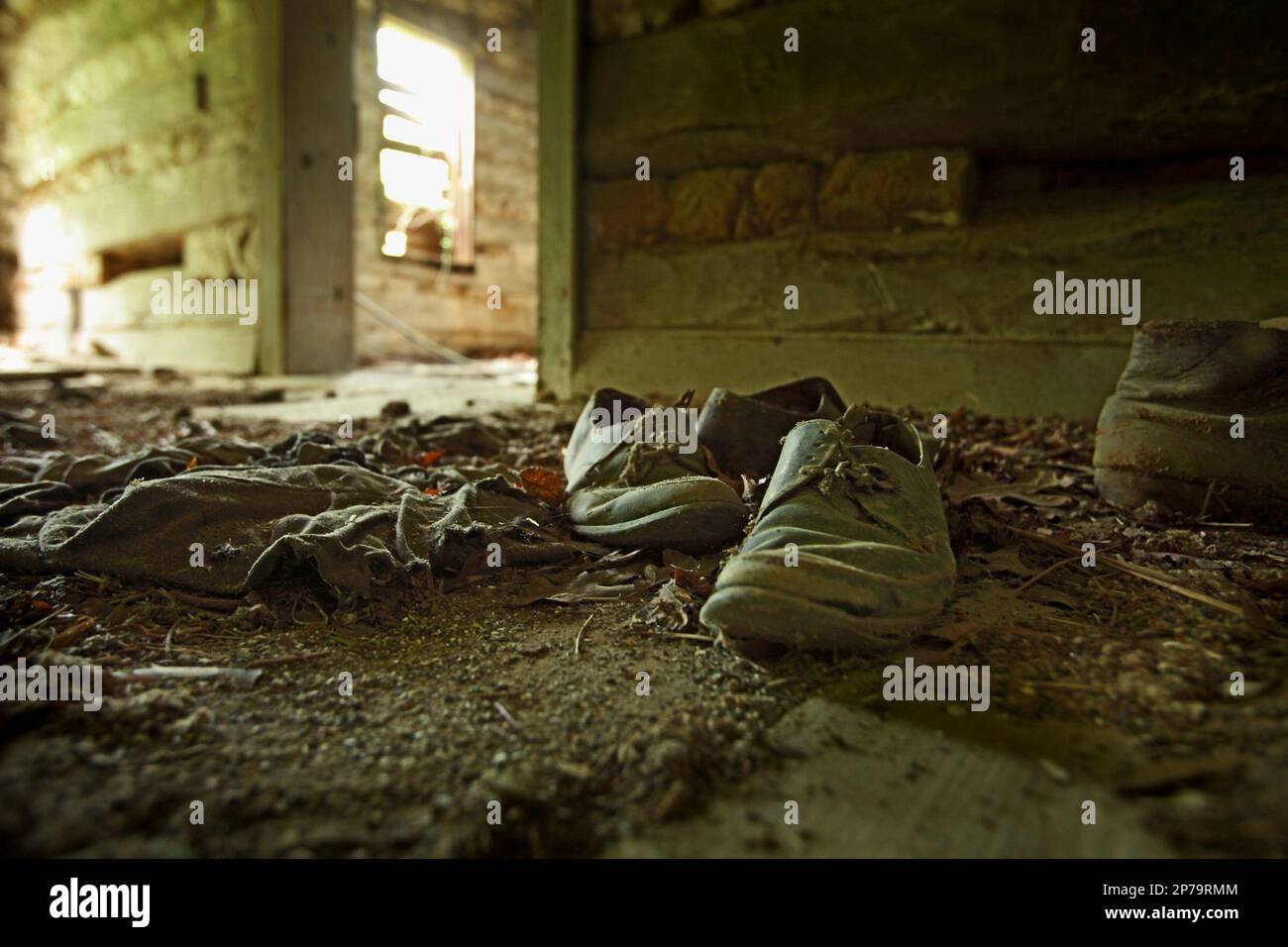 Remnants of past residents strewn on the floor of a small home made of ...