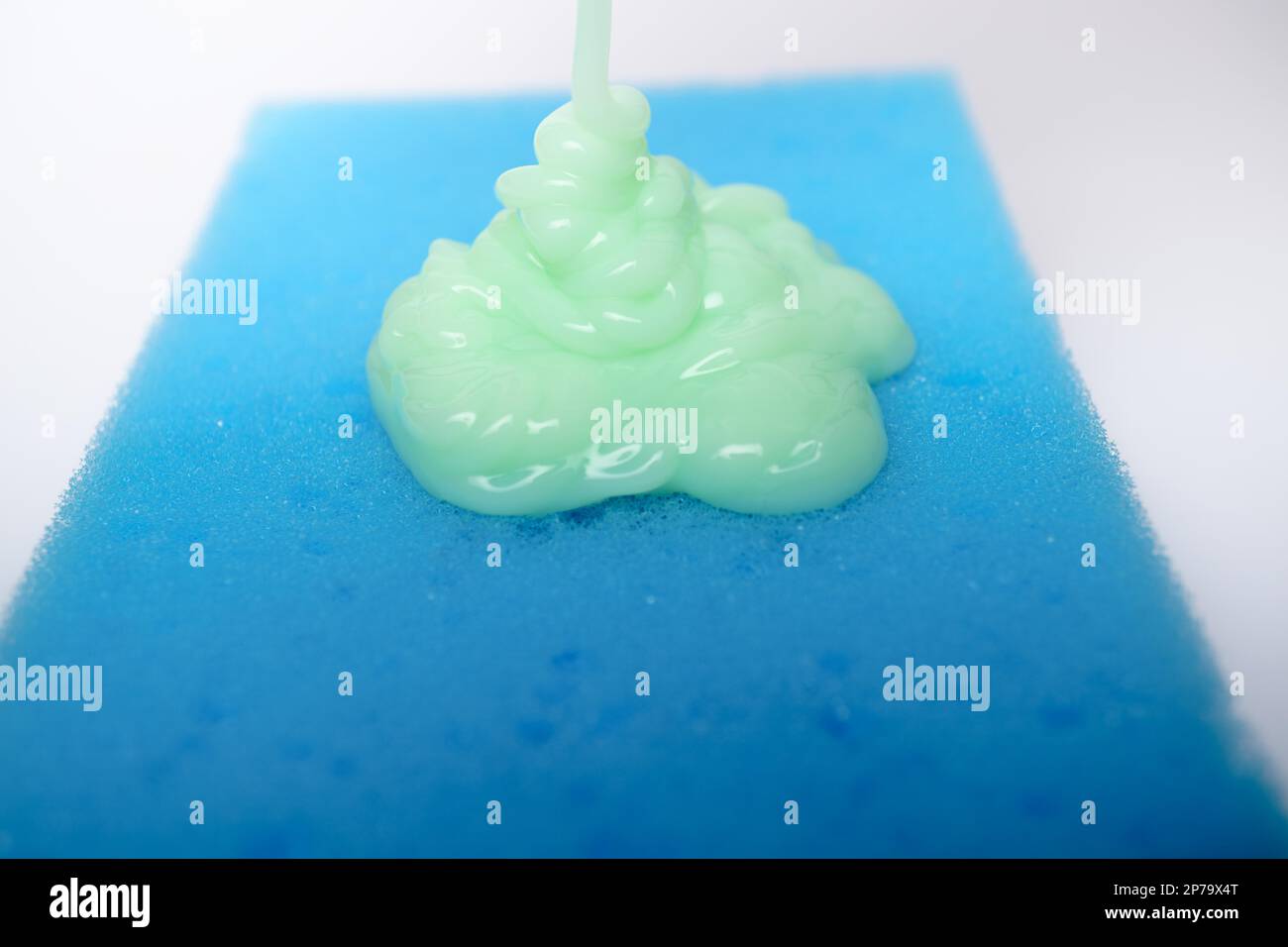 Green liquid soap dripping on a blue sponge on a white background Stock ...