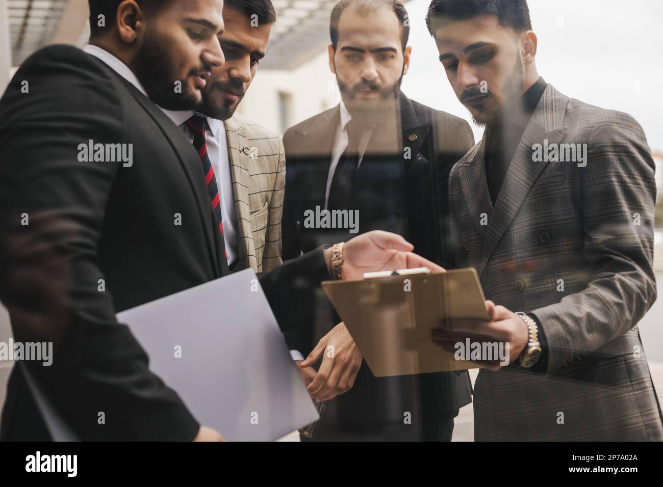 Business people outdoor meeting. Men in jackets discuss working moments ...