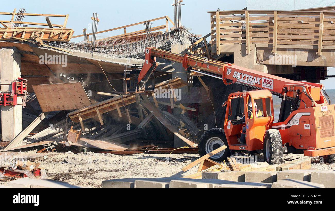 Construction crews use a forklift to push down the Bob Hall Pier ...
