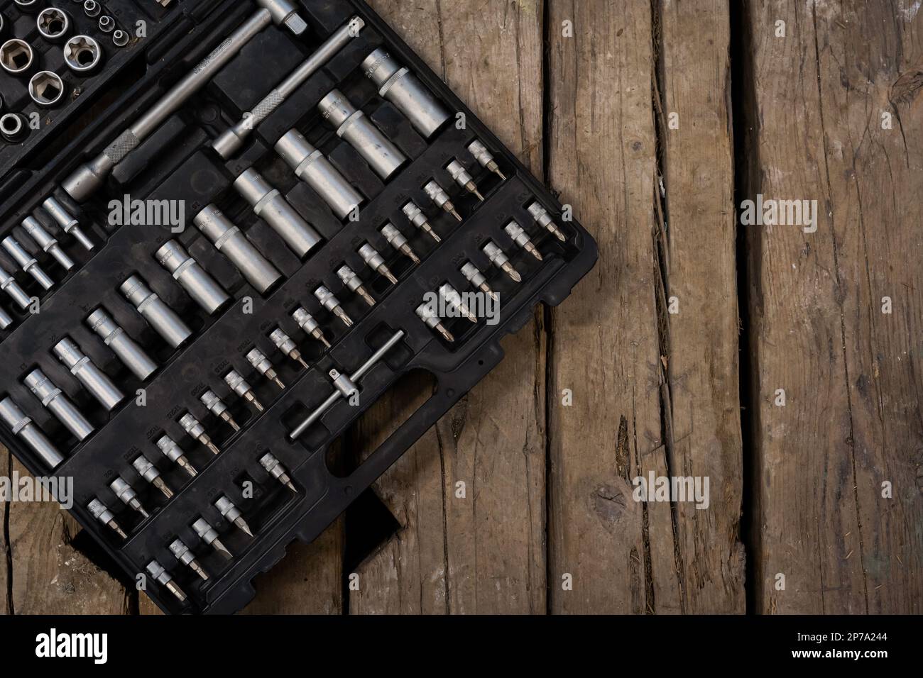 Close up of a opened tool box. Wooden background. Wrenches and bits ...
